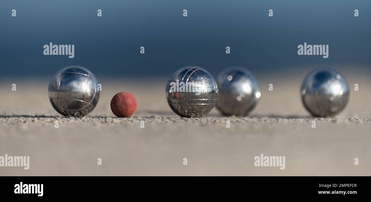 Metallic petanque four balls and a small wood jack Stock Photo - Alamy
