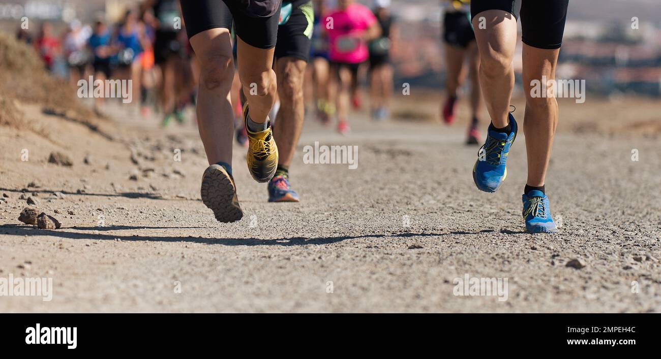 Runners running shoes on trail run. Ultra running athletes legs close ...