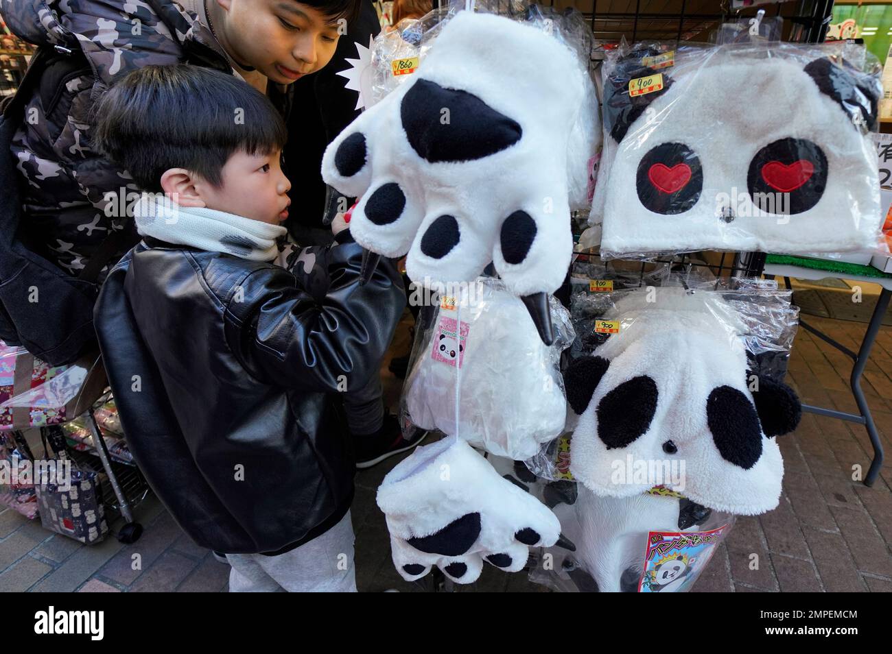 In this Sunday, Dec. 17, 2017, photo, children watch panda goods at an ...
