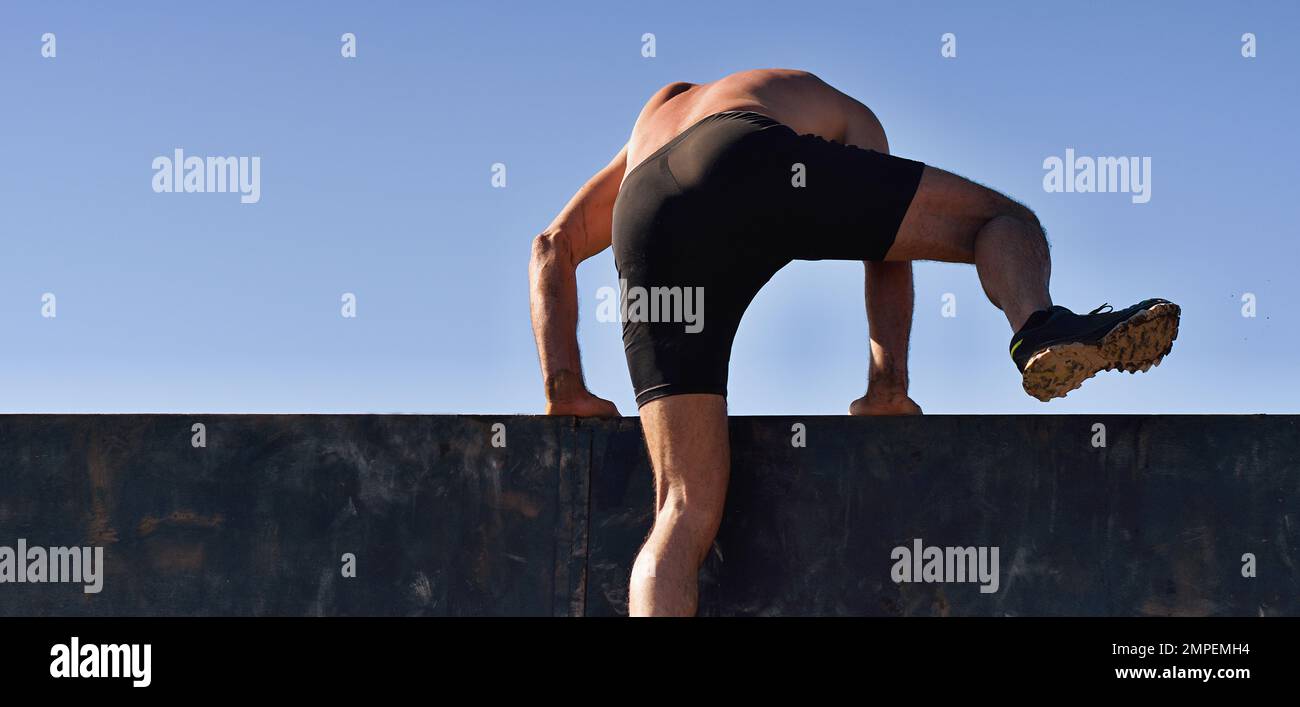 Mud race runners running over obstacles extreme sport Stock Photo - Alamy