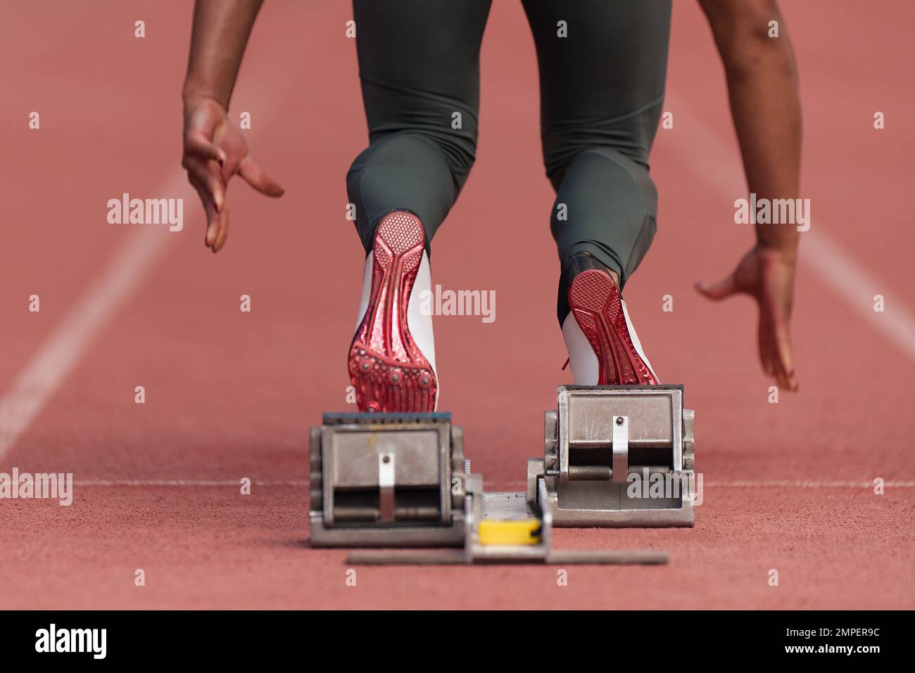 Back view of female feet on starting block ready for a sprint start ...