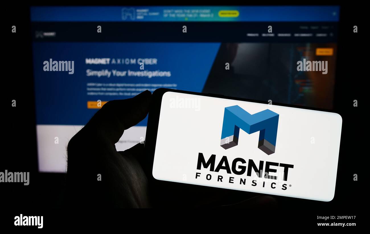 Person holding mobile phone with logo of cybersecurity company Magnet Forensics Inc. on screen ...