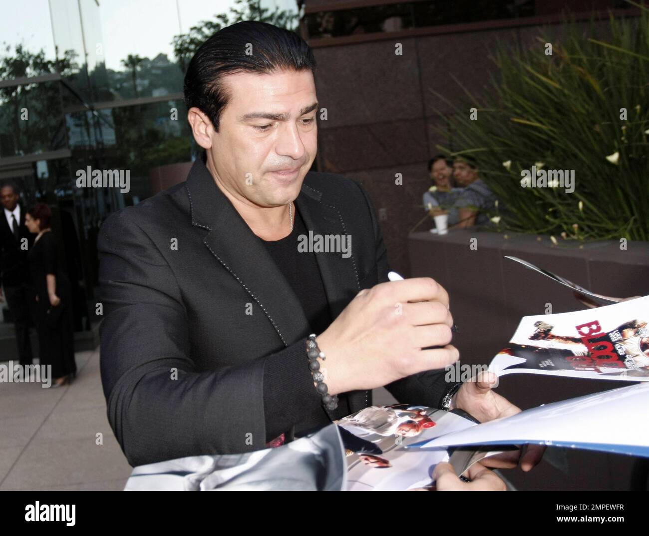 Actor Tamer Hassan smokes a cigarette as he signs autographs at the ...