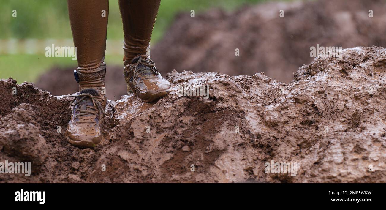 Mud race runners detail of the legs, muddy running shoes a run in the ...