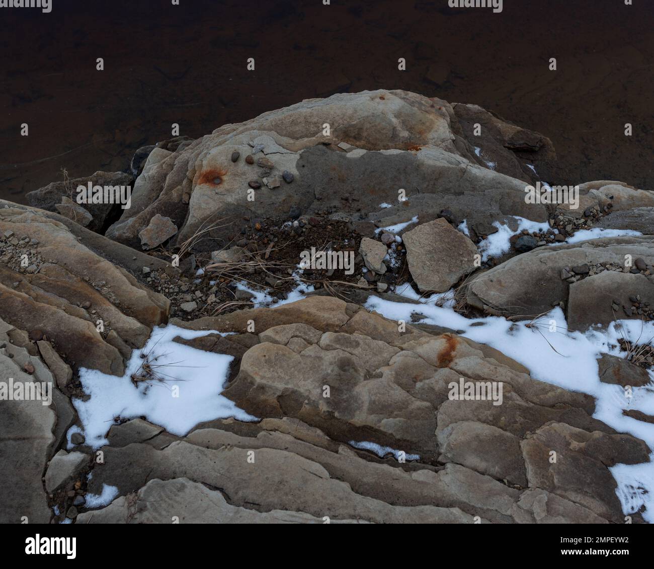 Abstract photo of a rocky rock on the shore with dark transparent water ...