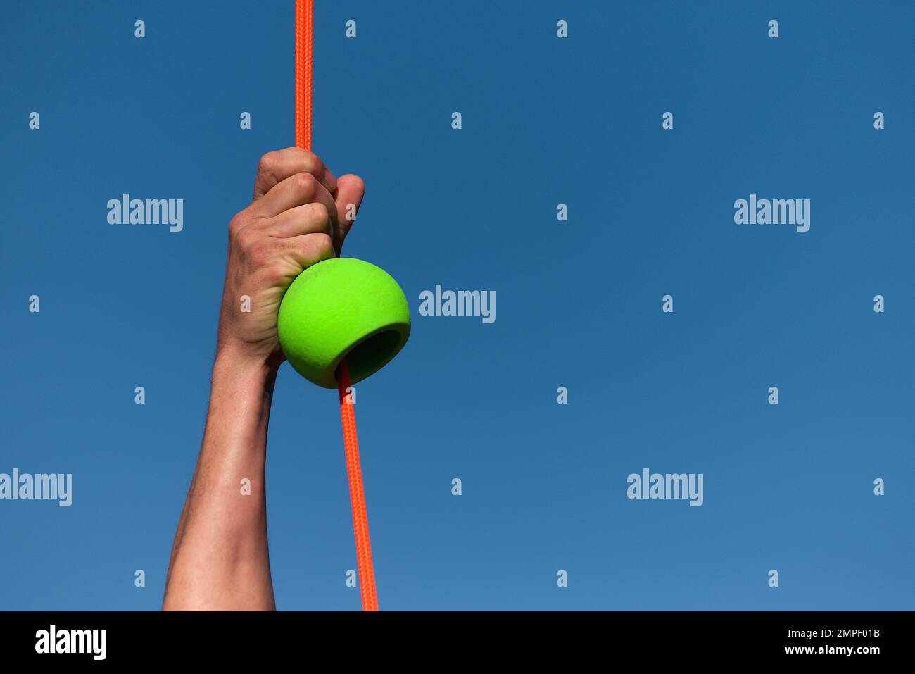 Athletic man working out and climbing a rope during obstacle course in ...