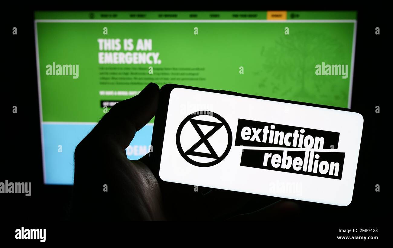 Person holding mobile phone with logo of organization Extinction ...