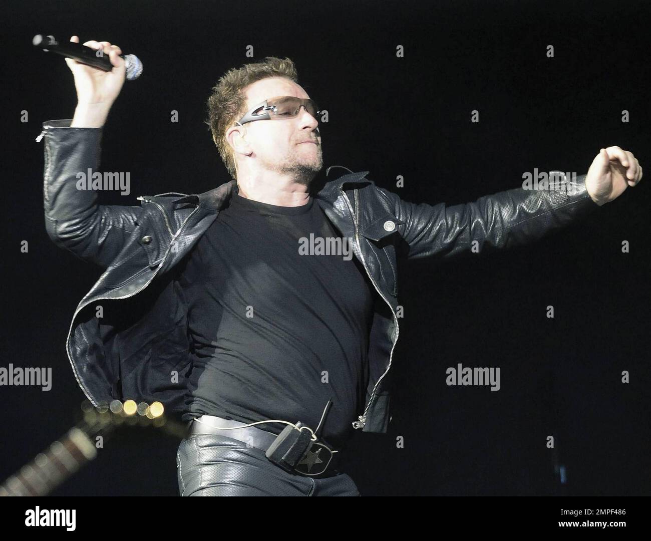 Veteran rock star Bono (aka Paul Hewson) wears tight black leather pants as he performs live in ...