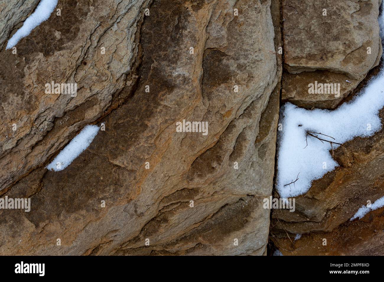 The texture of a stone rock with snow lying on it. The background is ...