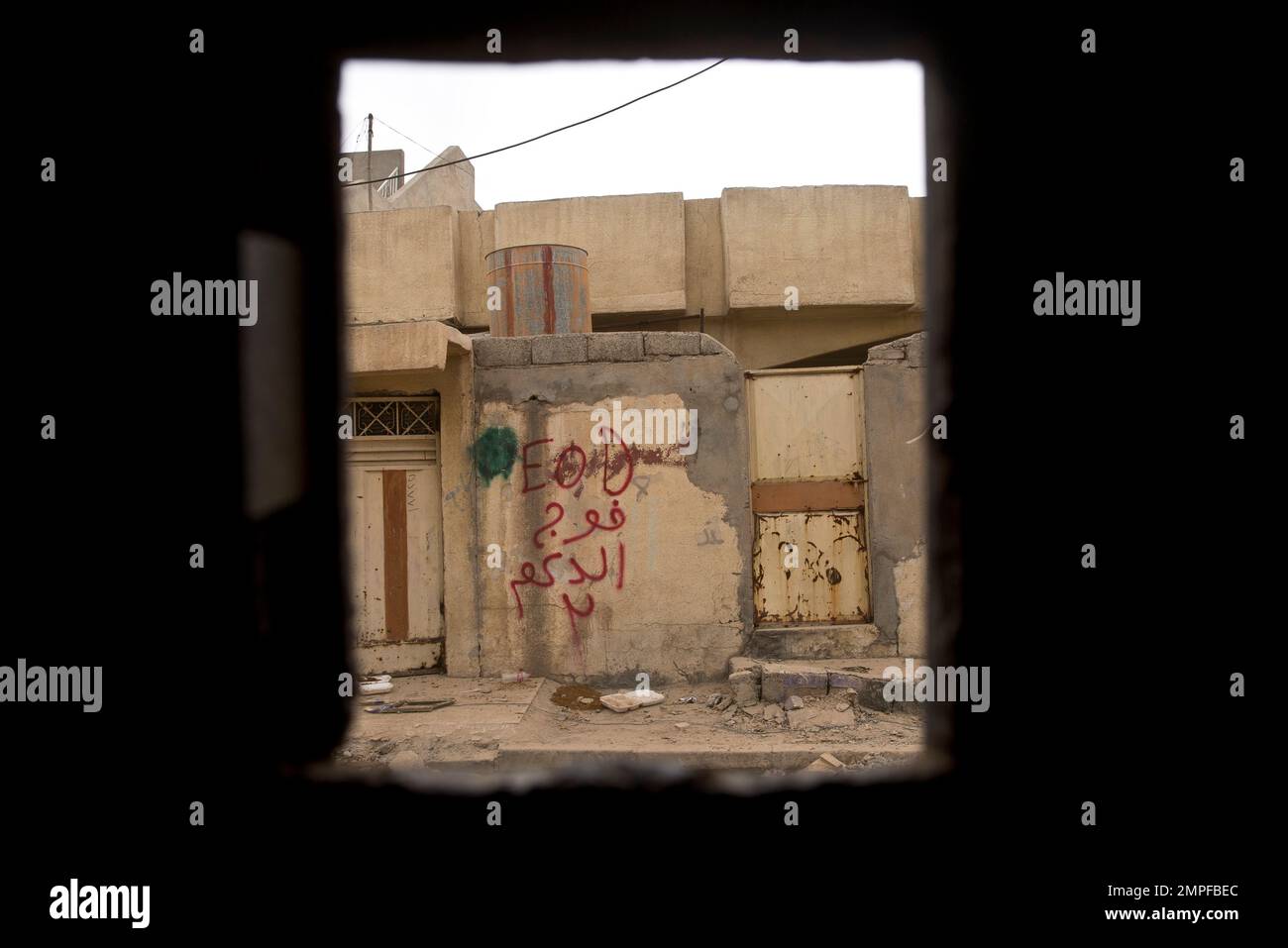 Seen through a Humvee window, a family home is marked with spray paint ...
