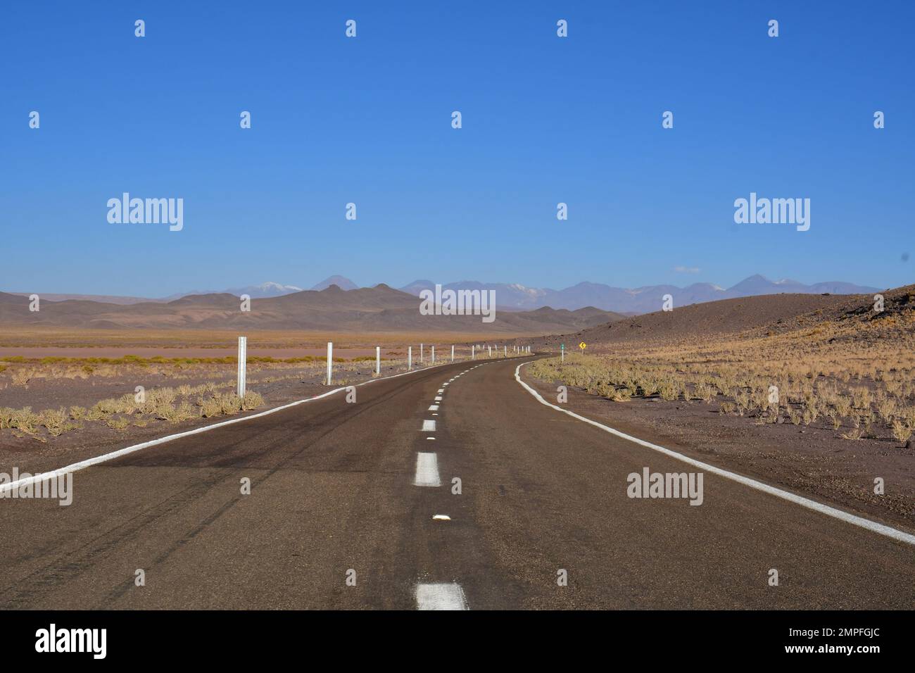 Lonely road curve desert bokeh chile South America Stock Photo - Alamy