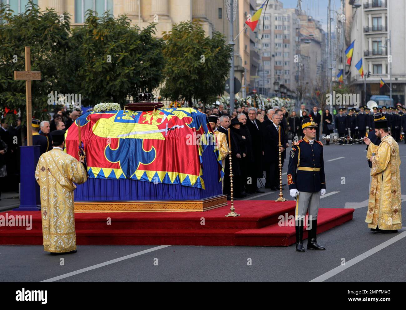 Priests perform a religious service next to the coffin of the late ...