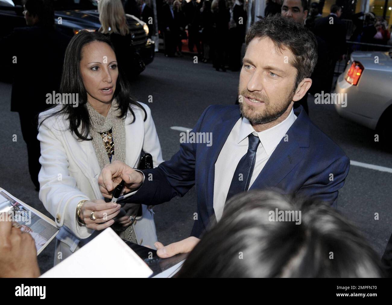Gerard Butler is all smiles as he greets fans and signs autographs ...