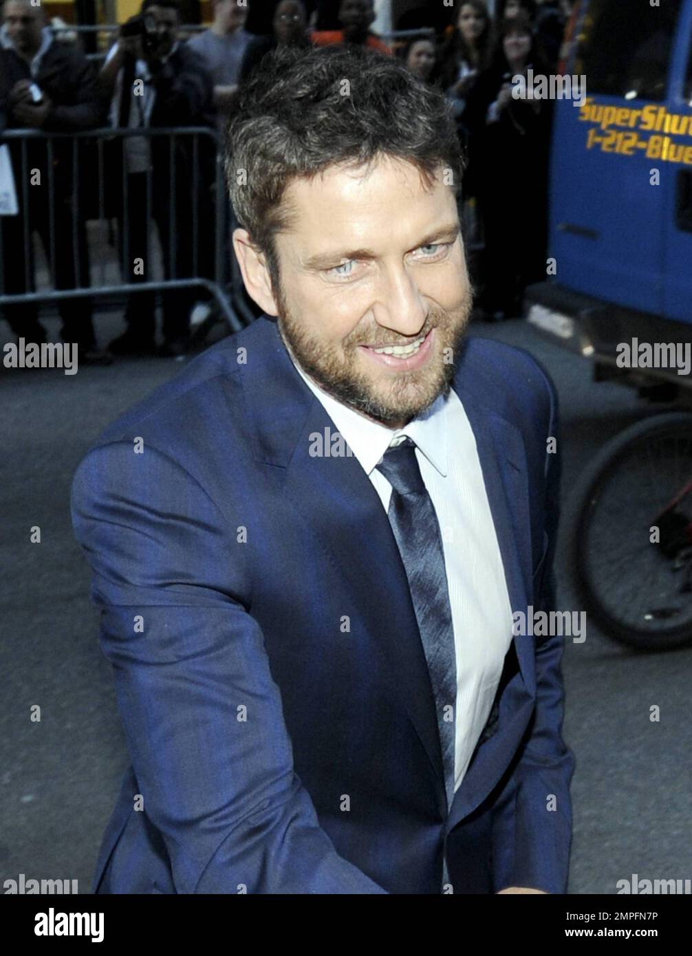 Gerard Butler is all smiles as he greets fans and signs autographs ...