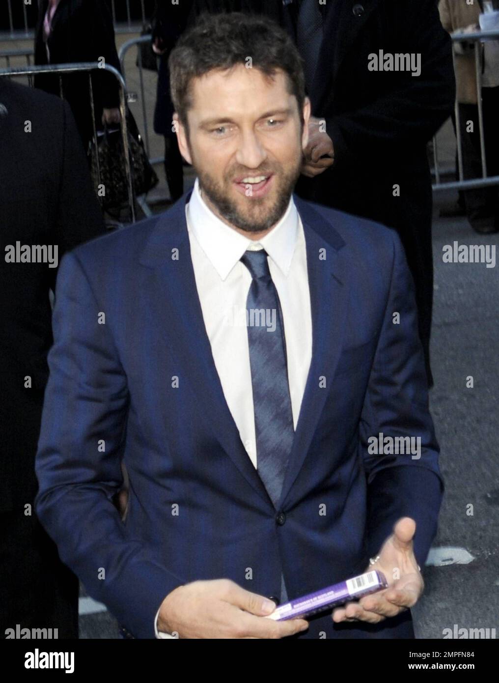 Gerard Butler is all smiles as he greets fans and signs autographs ...