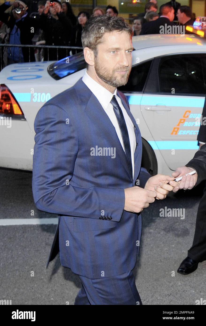 Gerard Butler is all smiles as he greets fans and signs autographs ...