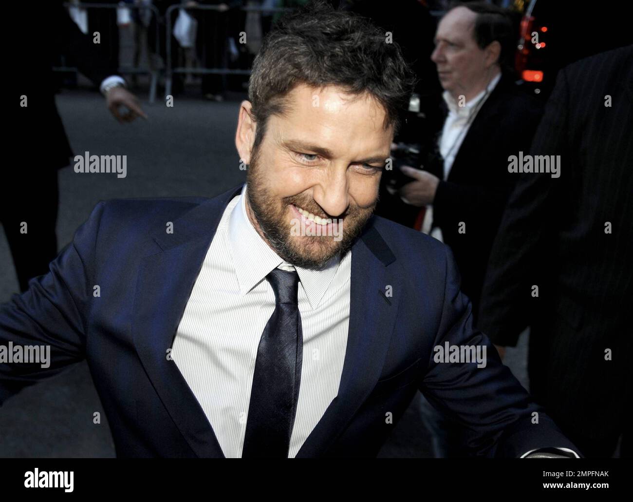 Gerard Butler is all smiles as he greets fans and signs autographs ...