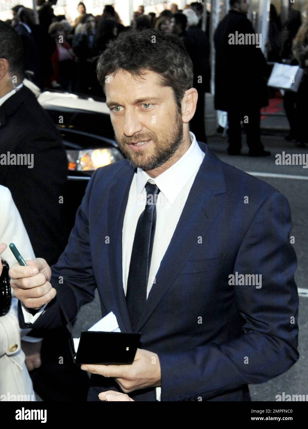 Gerard Butler is all smiles as he greets fans and signs autographs ...