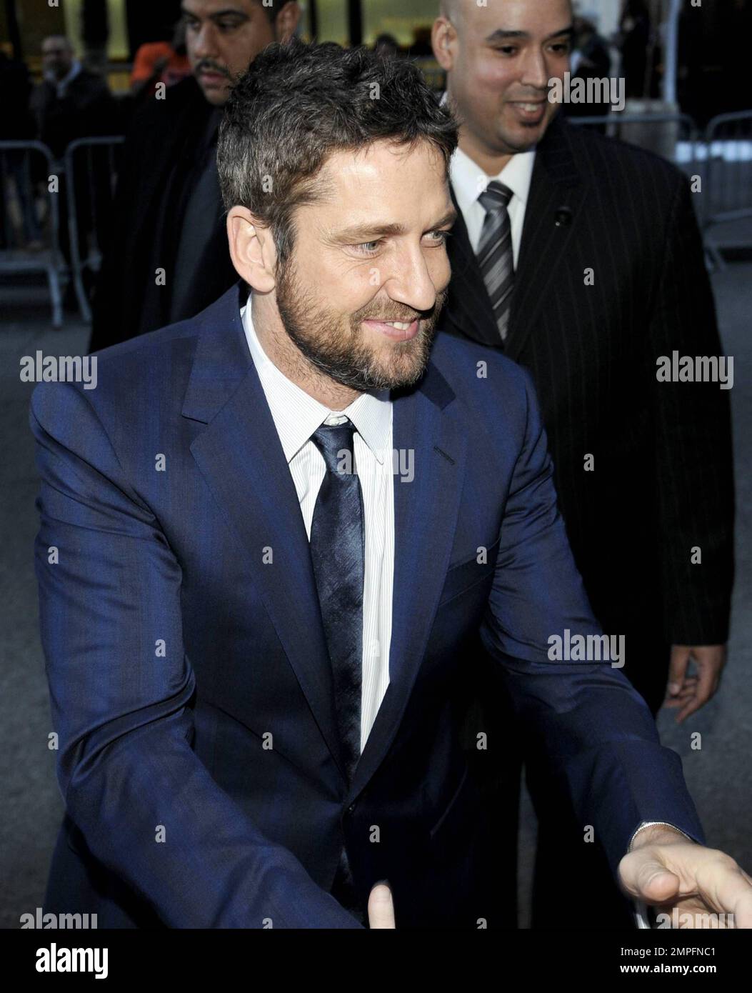 Gerard Butler is all smiles as he greets fans and signs autographs ...