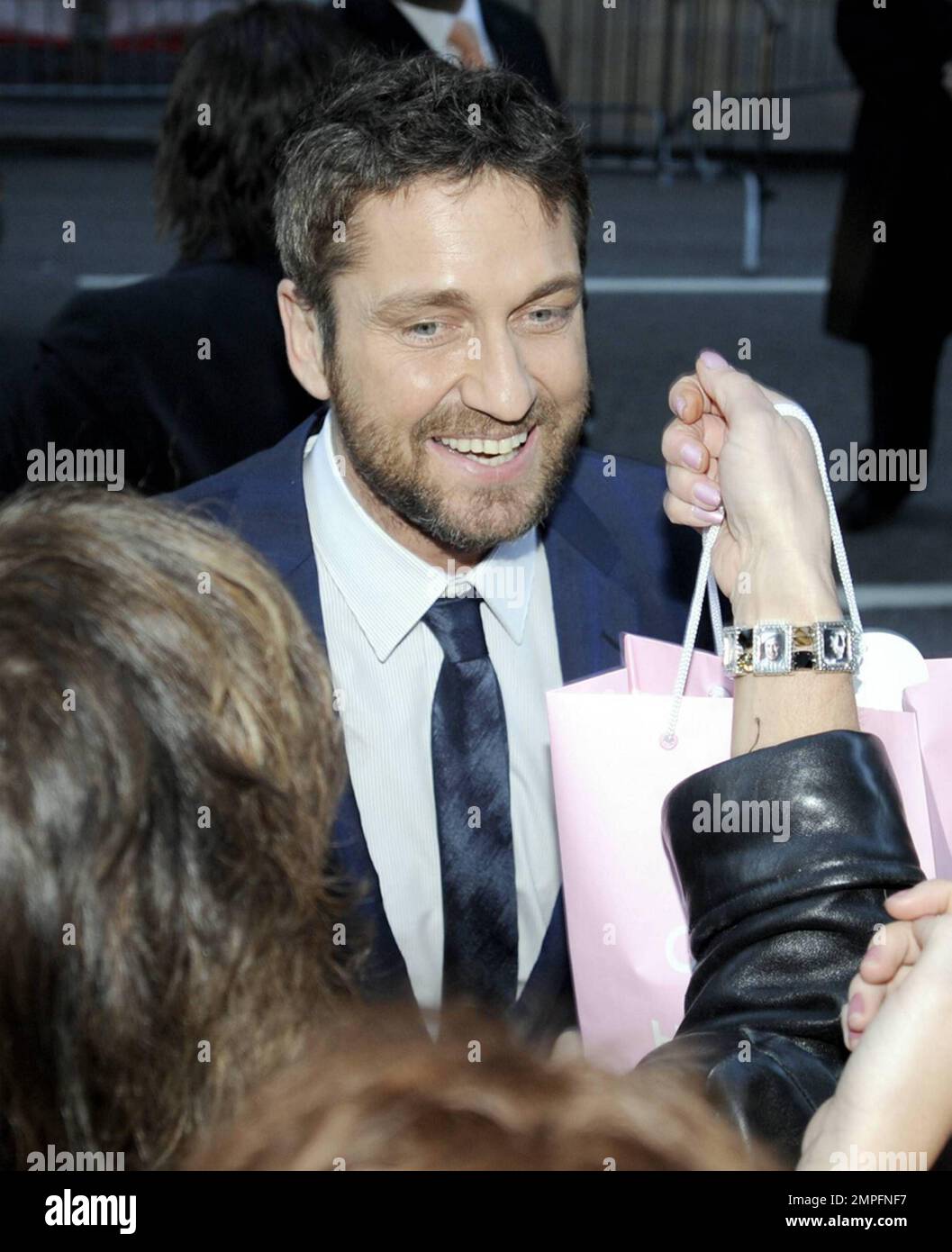 Gerard Butler is all smiles as he greets fans and signs autographs ...