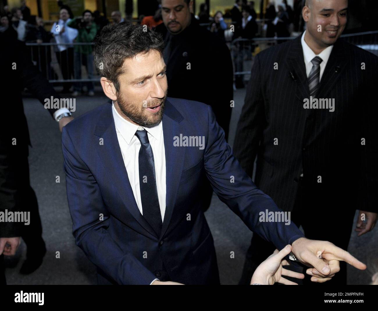 Gerard Butler is all smiles as he greets fans and signs autographs ...