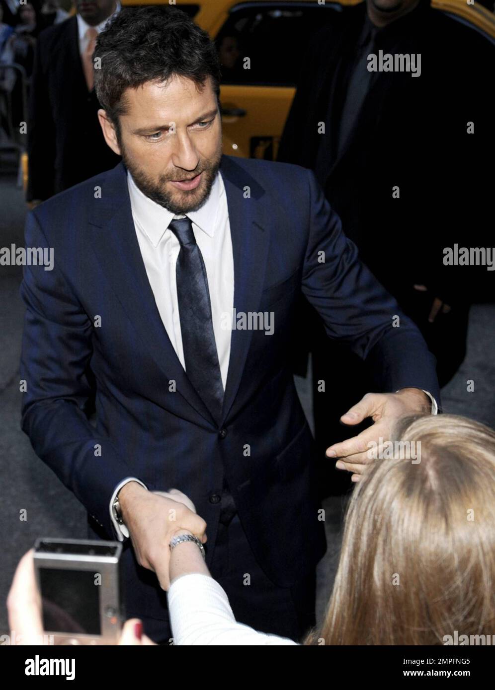 Gerard Butler is all smiles as he greets fans and signs autographs ...