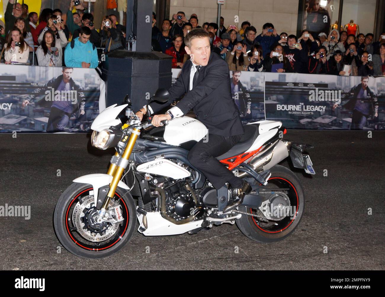 Jeremy Renner arrives on a motorcycle at the premiere of "The Bourne ...