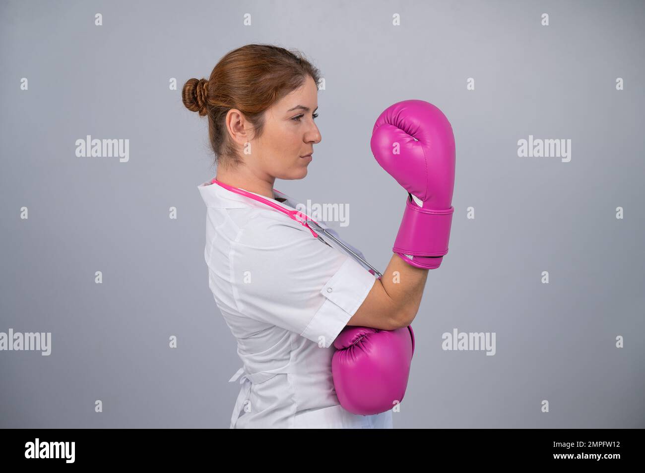 Woman doctor in pink boxing gloves on a white background Stock Photo ...
