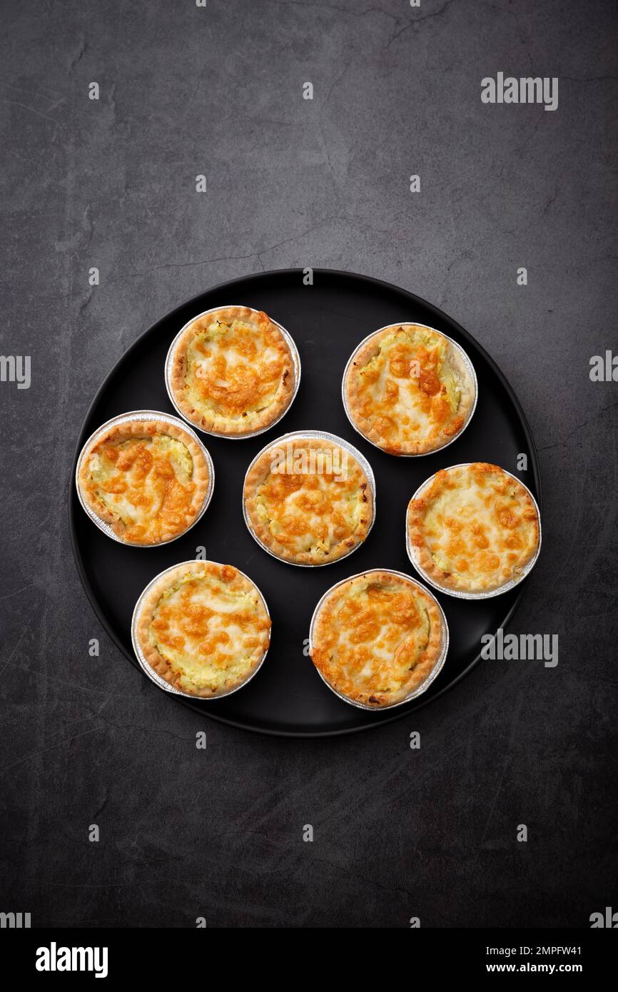 A vertical top view of little pot pies served on a black tray Stock ...