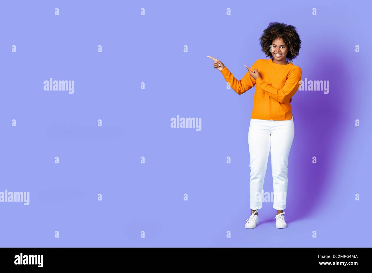 Full length of cheerful black lady pointing at copy space Stock Photo ...