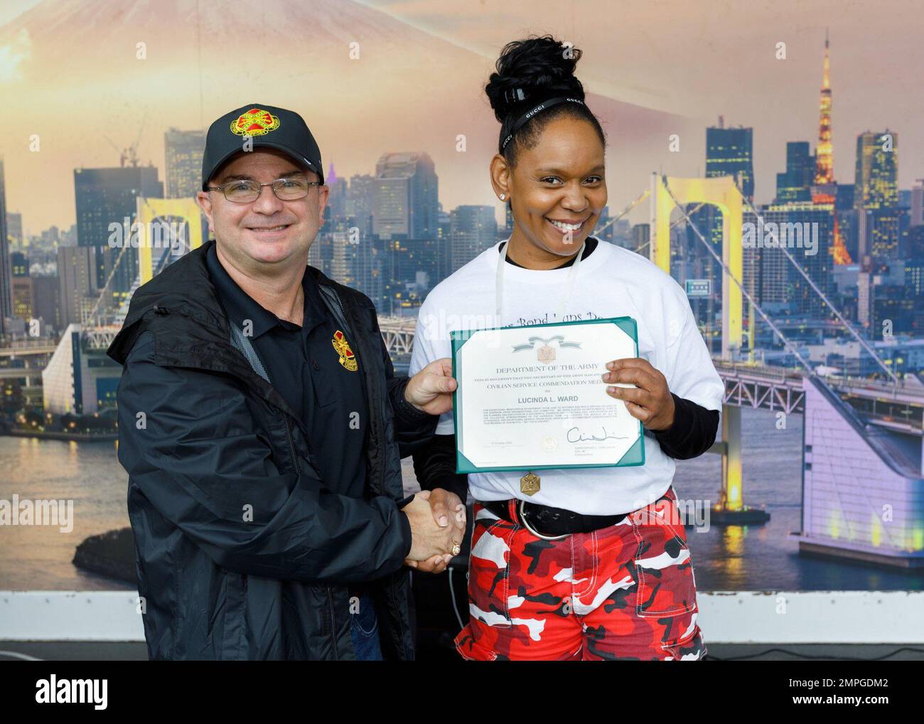 U.S. Army Garrison Japan Commander Col. Christopher Tomlinson presents ...