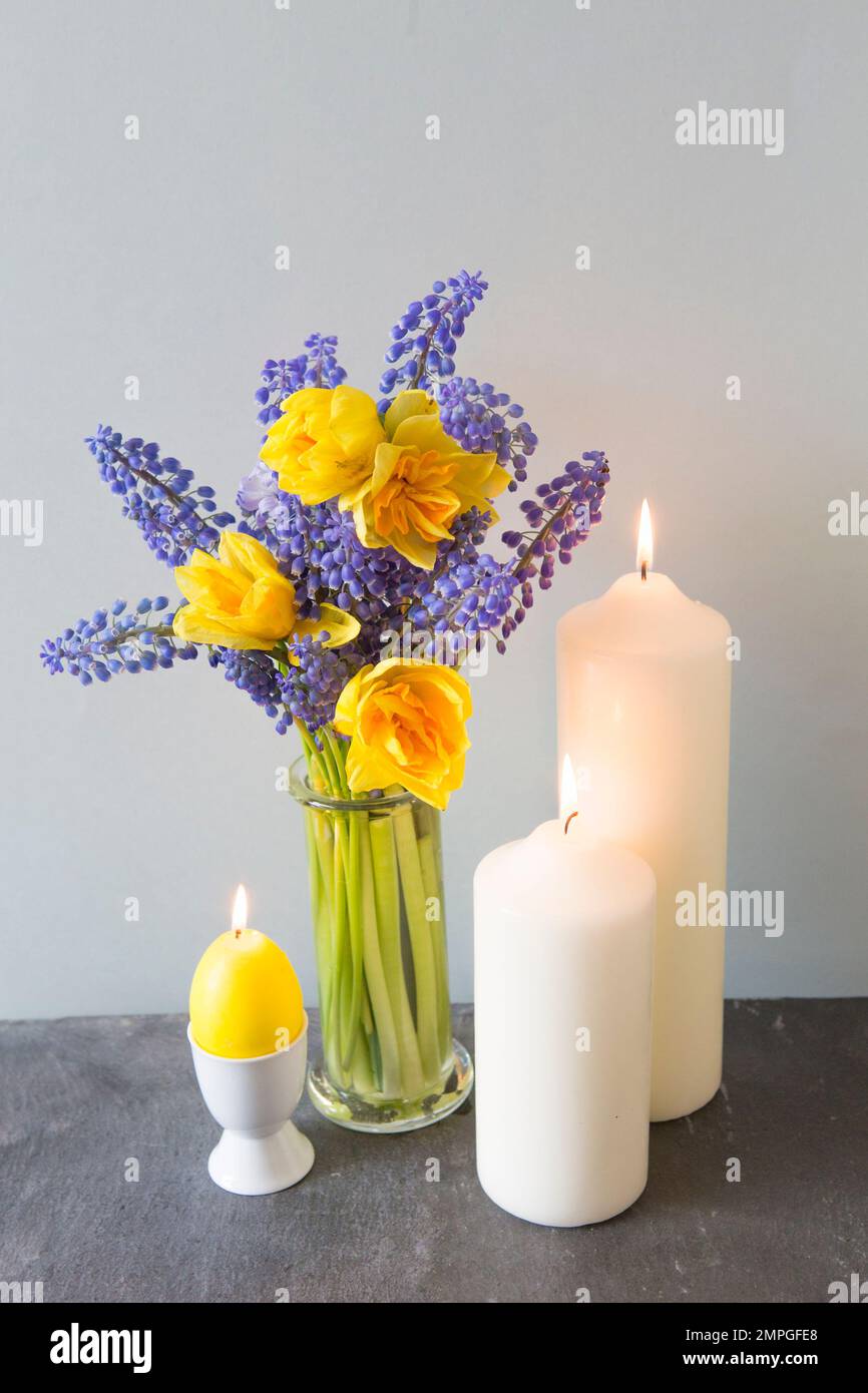 Easter arrangement with spring flowers and lighted candles Stock Photo ...