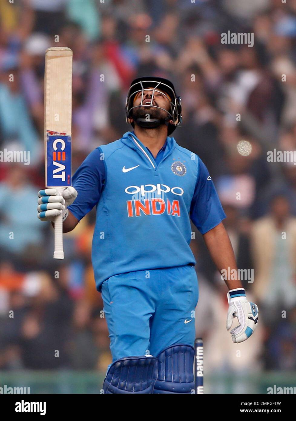 India's captain Rohit Sharma raises his bat as he looks skywards to ...