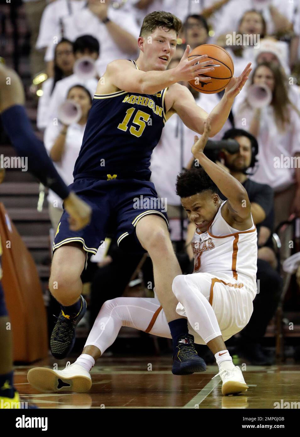 Michigan center Jon Teske (15) grabs a pass over Texas guard Jacob ...
