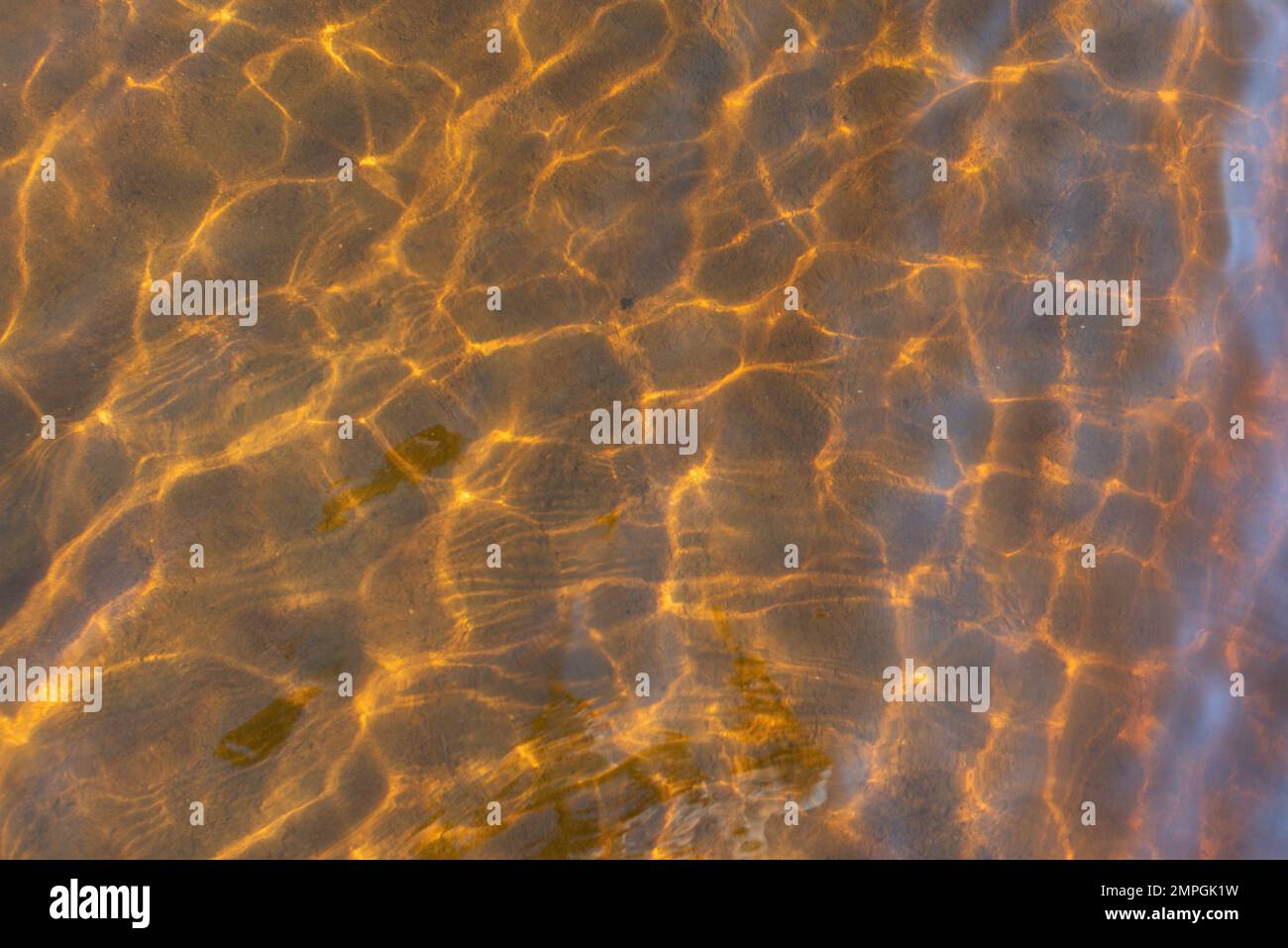 Bright reflection of the sun from the waves of clear clear water. The ...