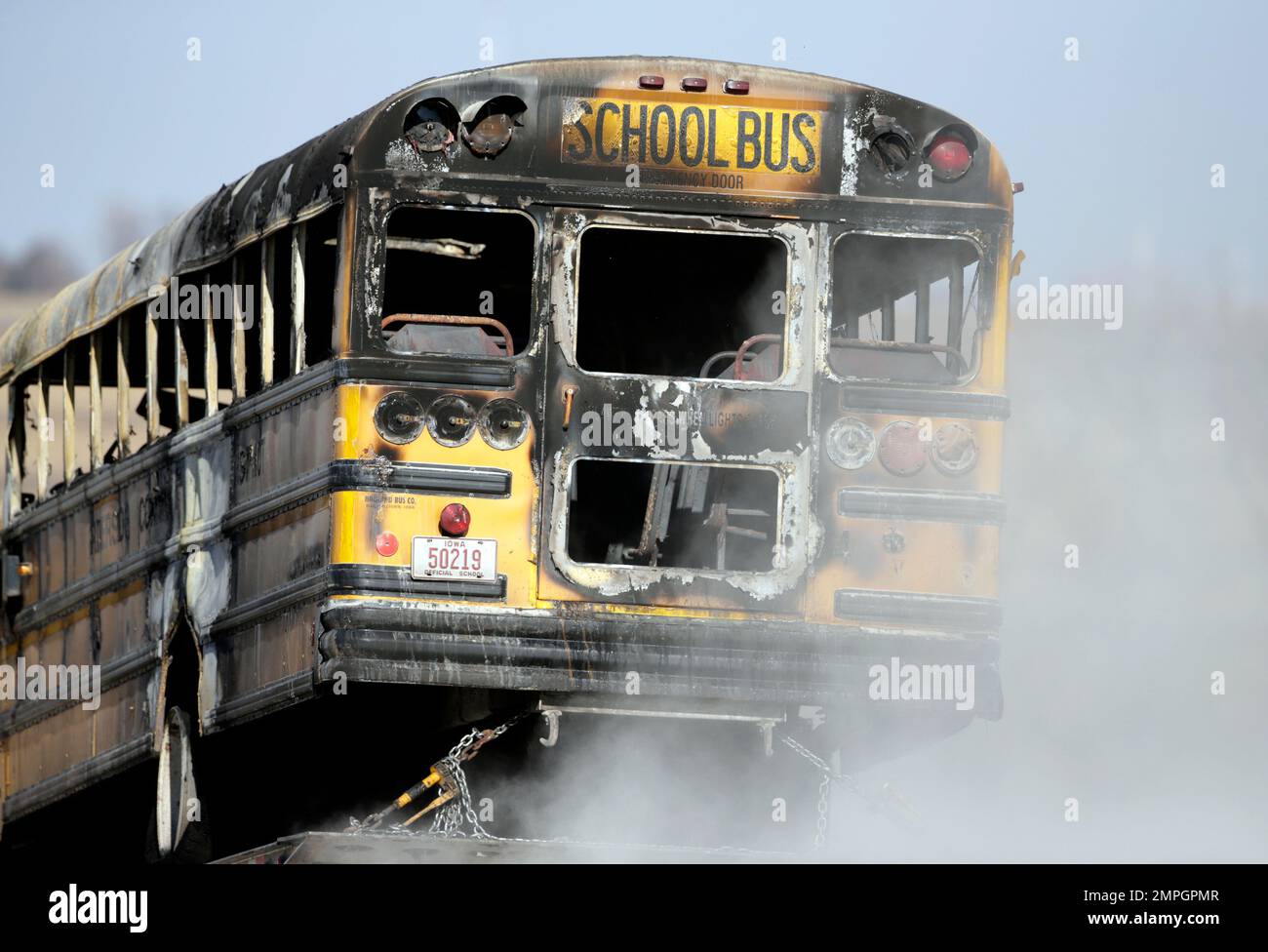 A burned school bus is transported by trailer near Oakland, Iowa ...