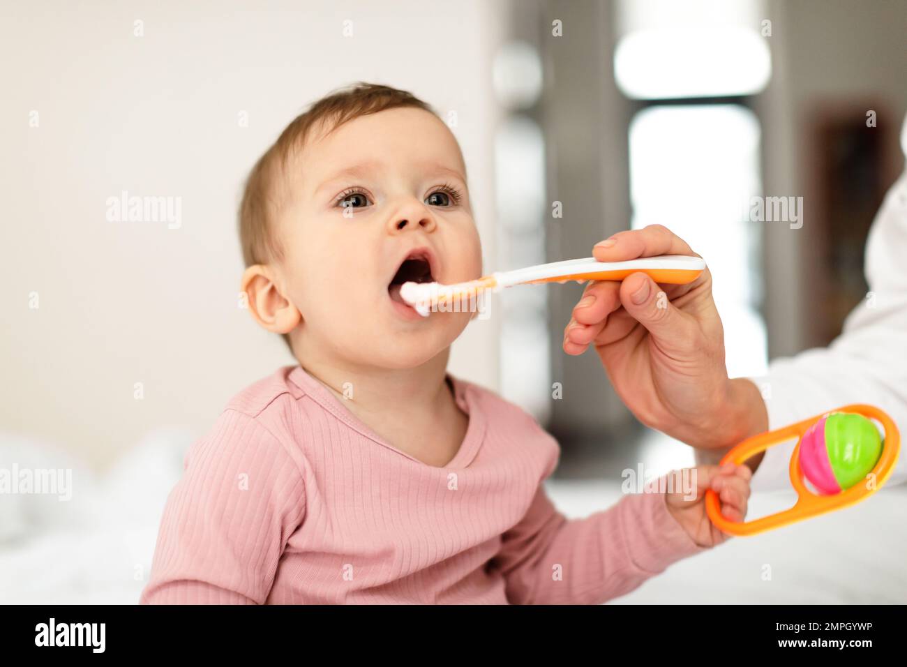 Baby feeding concept. Cute little infant girl opening mouth and eating ...