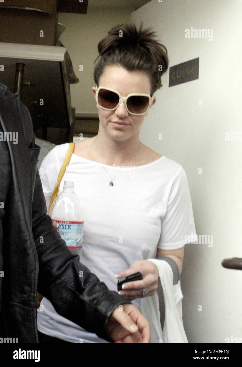 Accompanied by a bodyguard, Britney Spears wears a ring on her ...