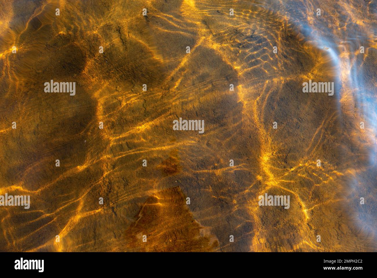 Bright reflection of sunlight from the waves of transparent clear water ...