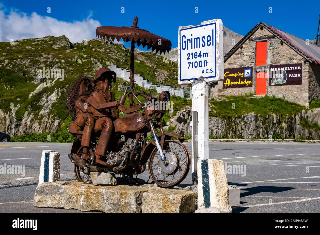 Artful rusty statue of two people sitting on a motobike and the ...