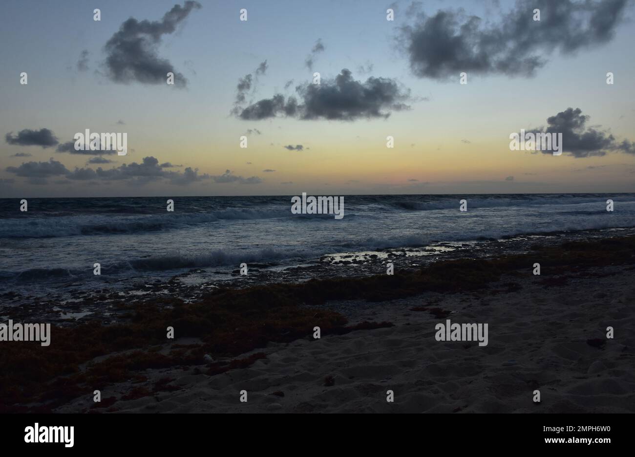 View of a the sun beginning to rise over the ocean waters Stock Photo ...