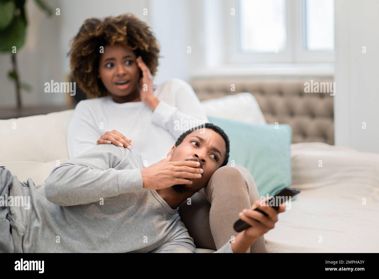 Scared african american man and woman watching TV Stock Photo - Alamy