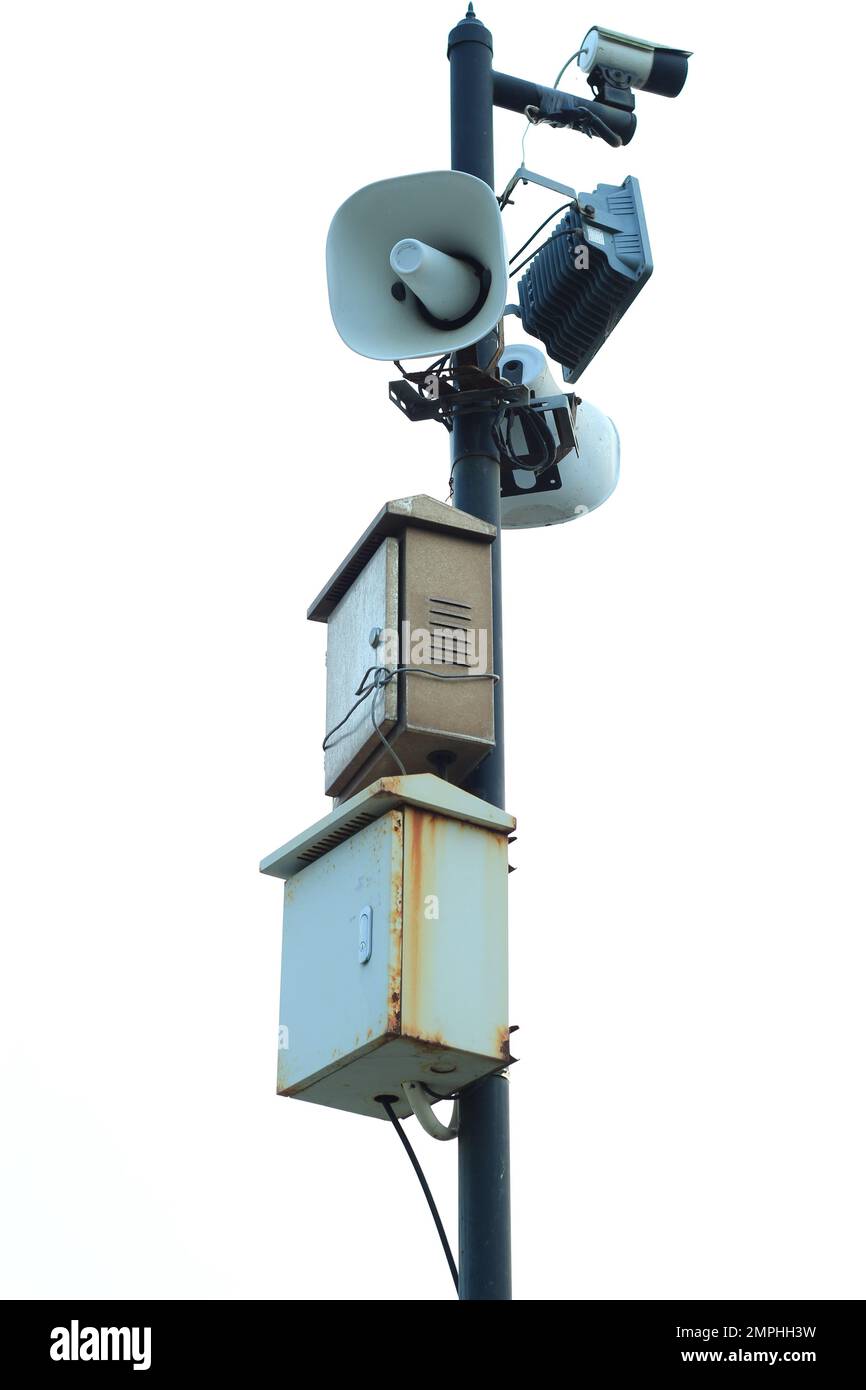 A vertical shot of an outdoor warning siren and a camera attached to a ...