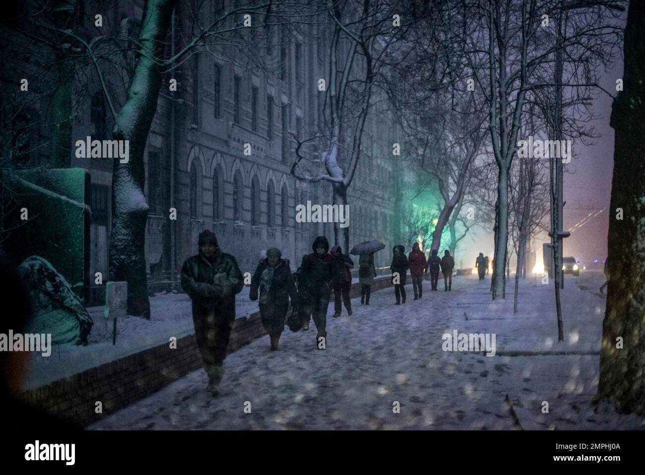 People walk down a street during a snowfall in Kiev, Ukraine, Sunday ...