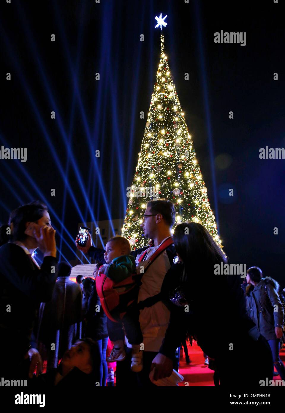 A Lebanese family take a selfie near a giant Christmas tree, set in ...