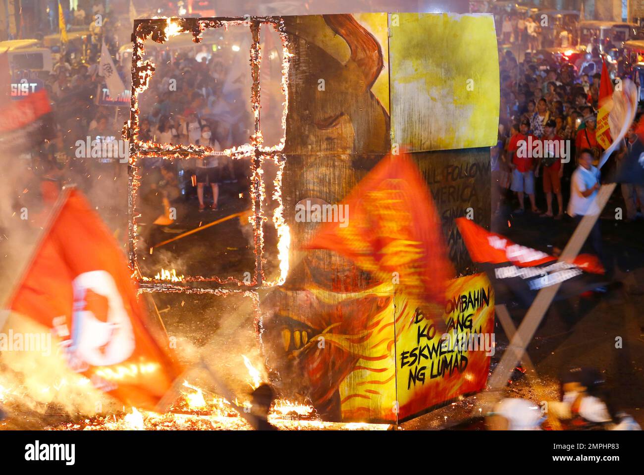 Protesters dance around the burning effigy of President Rodrigo Duterte ...