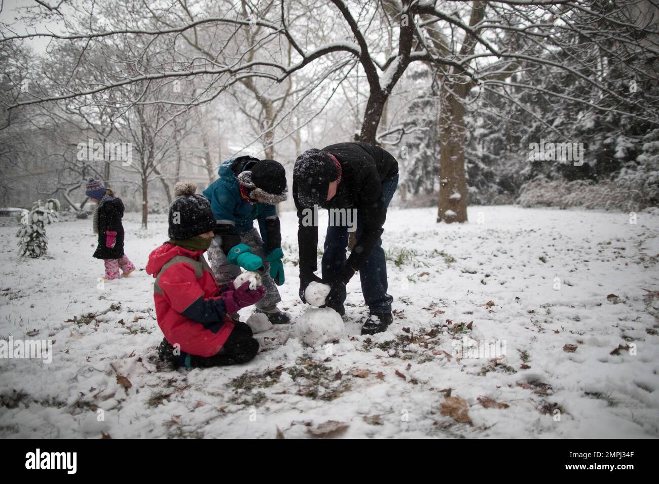 Snow falls on Tom Hollladay, right, as he makes a snowman in City Hall ...