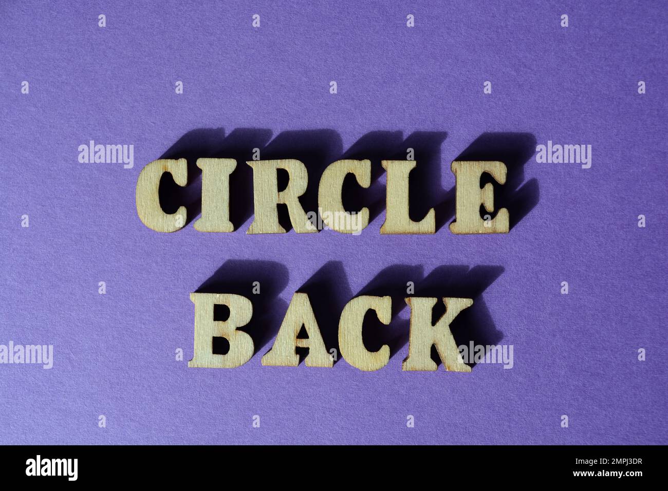 Circle Back, words in wooden alphabet letters isolated on purple ...