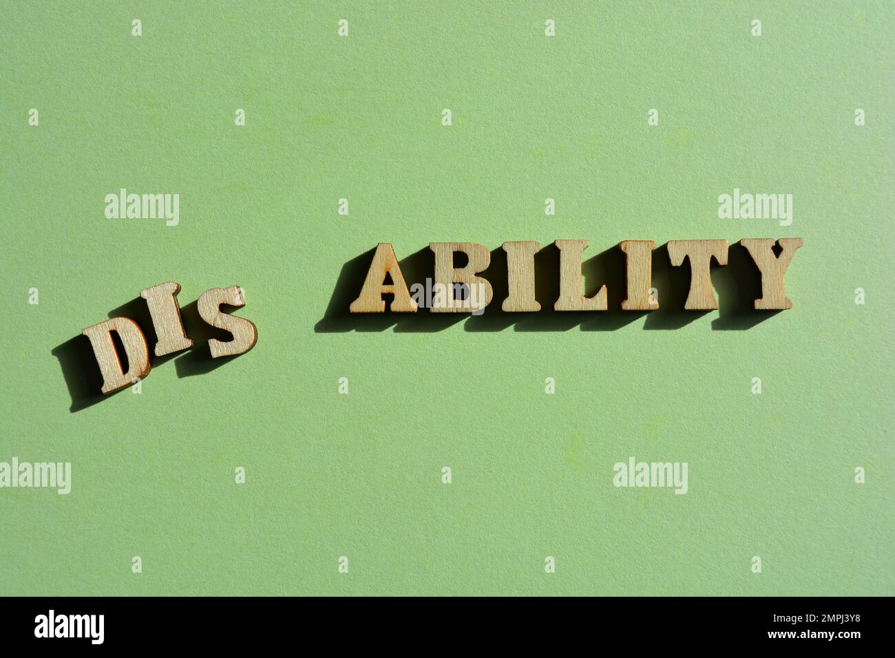 Disability, ability, word in wooden alphabet letters isolated on green ...