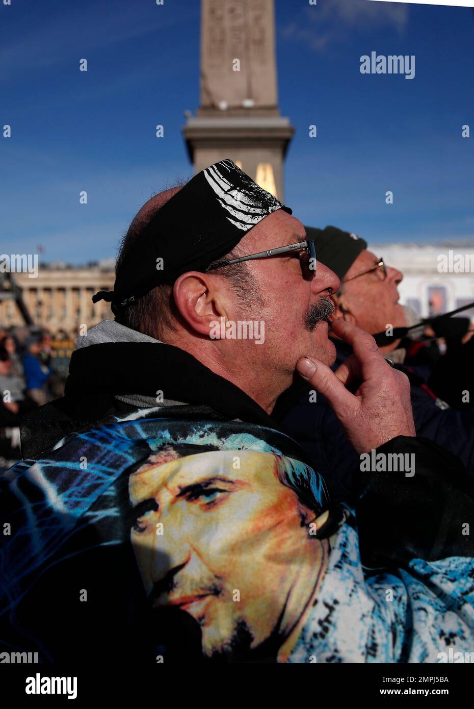 A fan watches Johnny Hallyday's funeral ceremony on a giant screen in ...